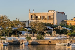 Imóvel à beira-mar com um edifício moderno, área de estar ao ar livre e barcos atracados.