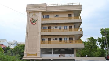 Um edifício com várias andares, varandas e fachada decorativa.
