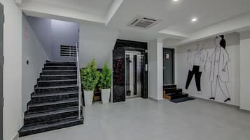 Decoração moderna com escadaria, sala de estar e uma parede com obra de arte minimalista.