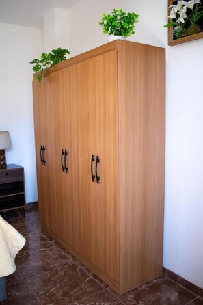 Guarda-roupa de madeira com duas portas e uma prateleira no topo.