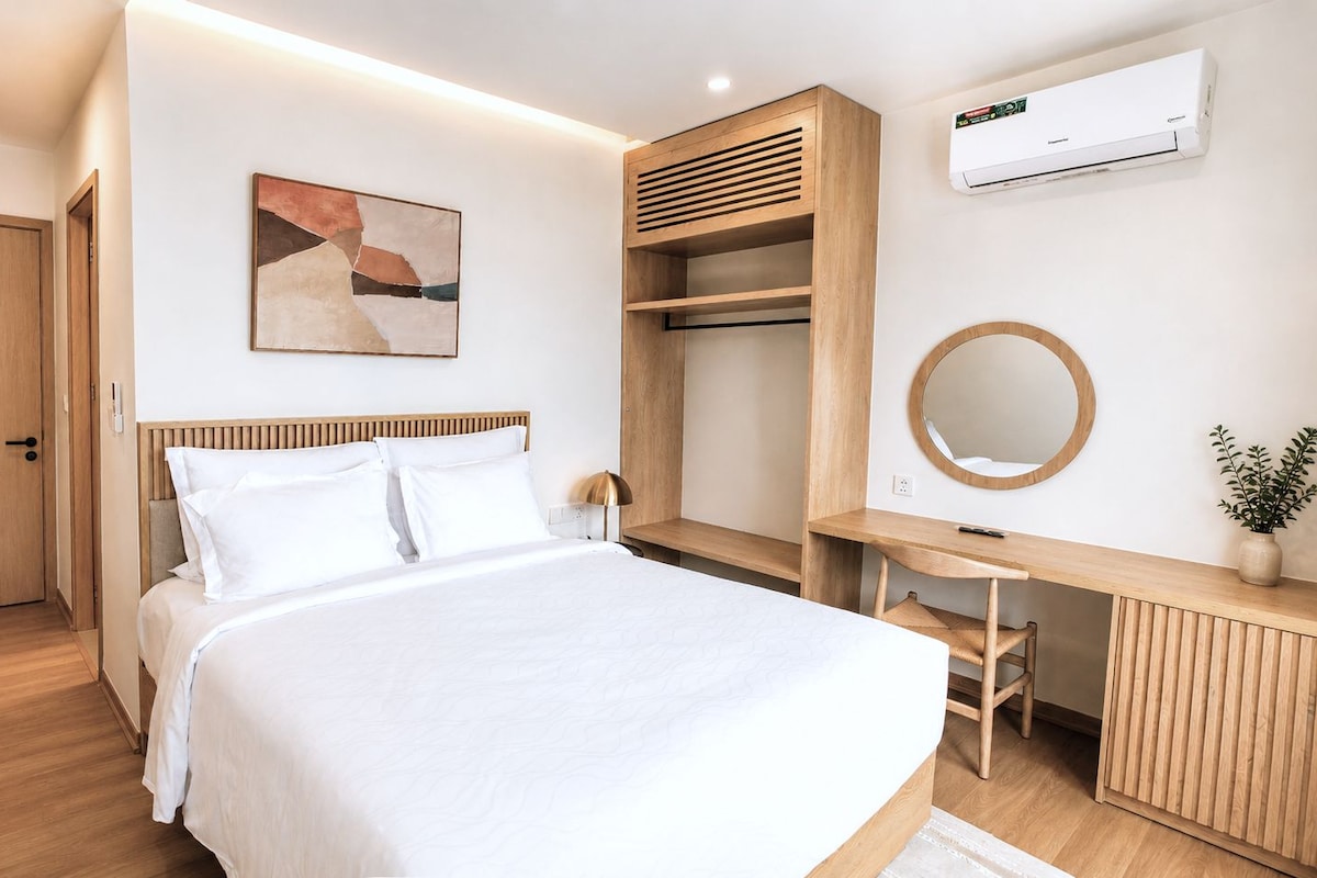 Quarto moderno com cama, mesa de cabeceira, escrivaninha e guarda-roupa.