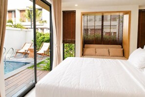 Quarto com cama grande, vista para uma piscina e varanda com cadeiras.