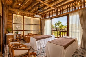Quarto com teto de madeira, duas camas, banheira e vista para palmeiras.