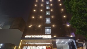 Um edifício de vários andares com uma placa indicando 'OYO TOWNHOUSE AMERPET'.