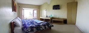 Quarto com cama, escrivaninha, guarda-roupa, espelho e janela.