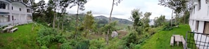 Zona residencial com vista para um vale, rodeada por vegetação e alguns edifícios.