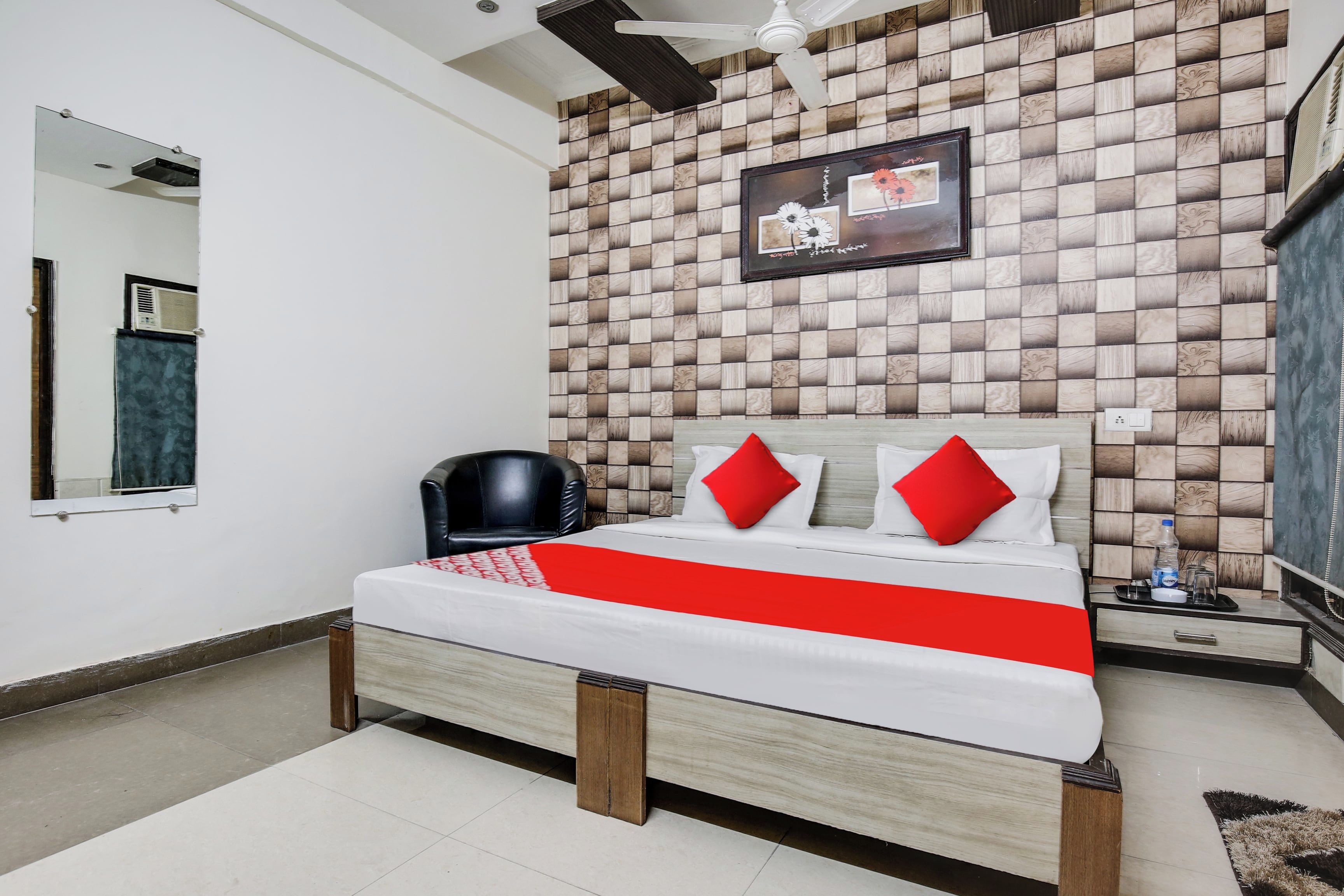 Quarto com cama, cadeira, espelho, quadro na parede e ventoinha de teto.