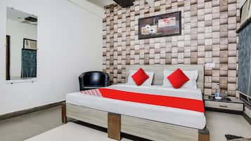 Quarto com cama, cadeira, espelho, quadro na parede e ventoinha de teto.