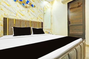 Quarto de hotel com uma cama, cabeceira, ar condicionado fixado na parede e uma porta.