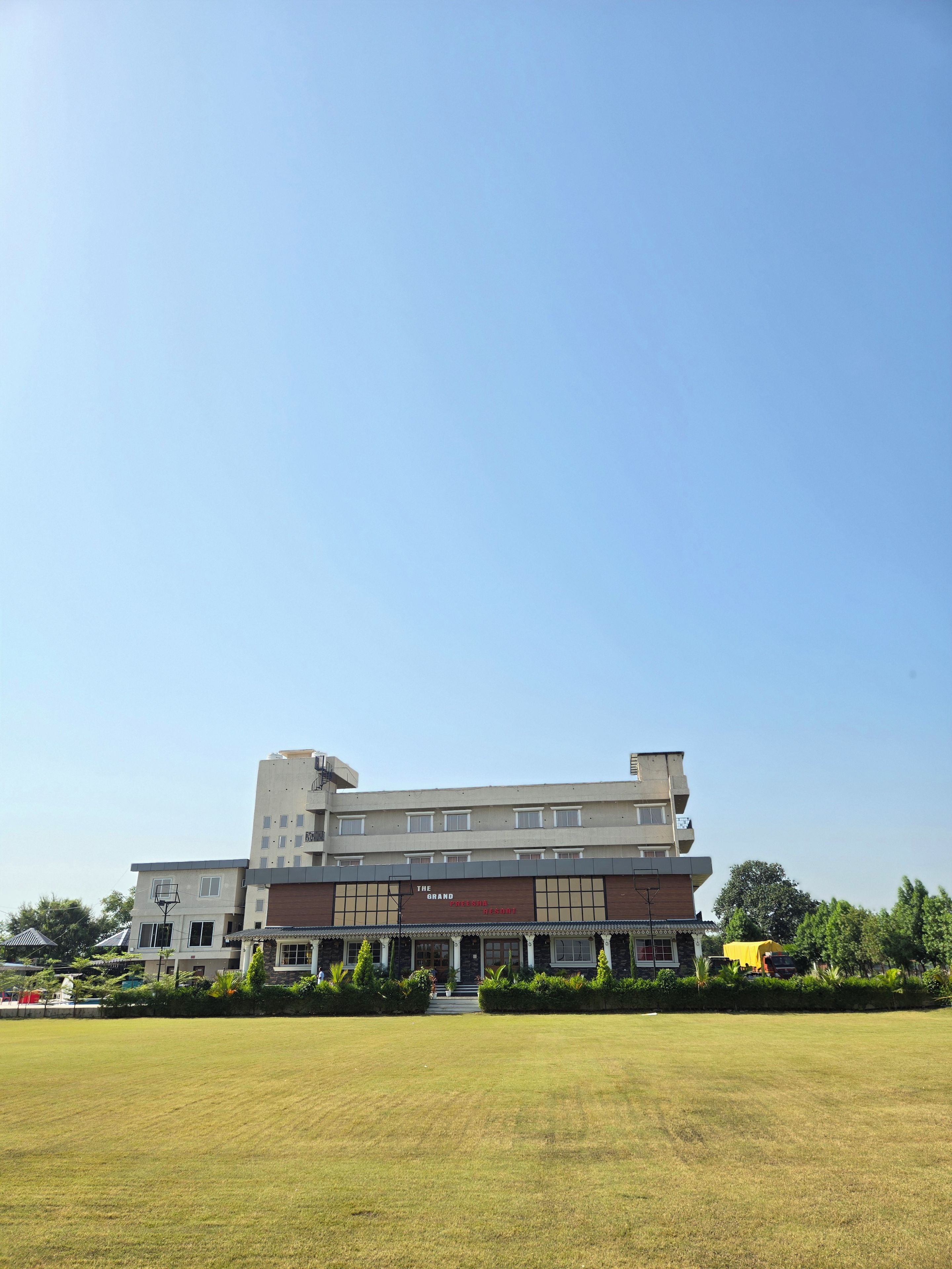 Um edifício de vários andares com telhado plano e entrada central.