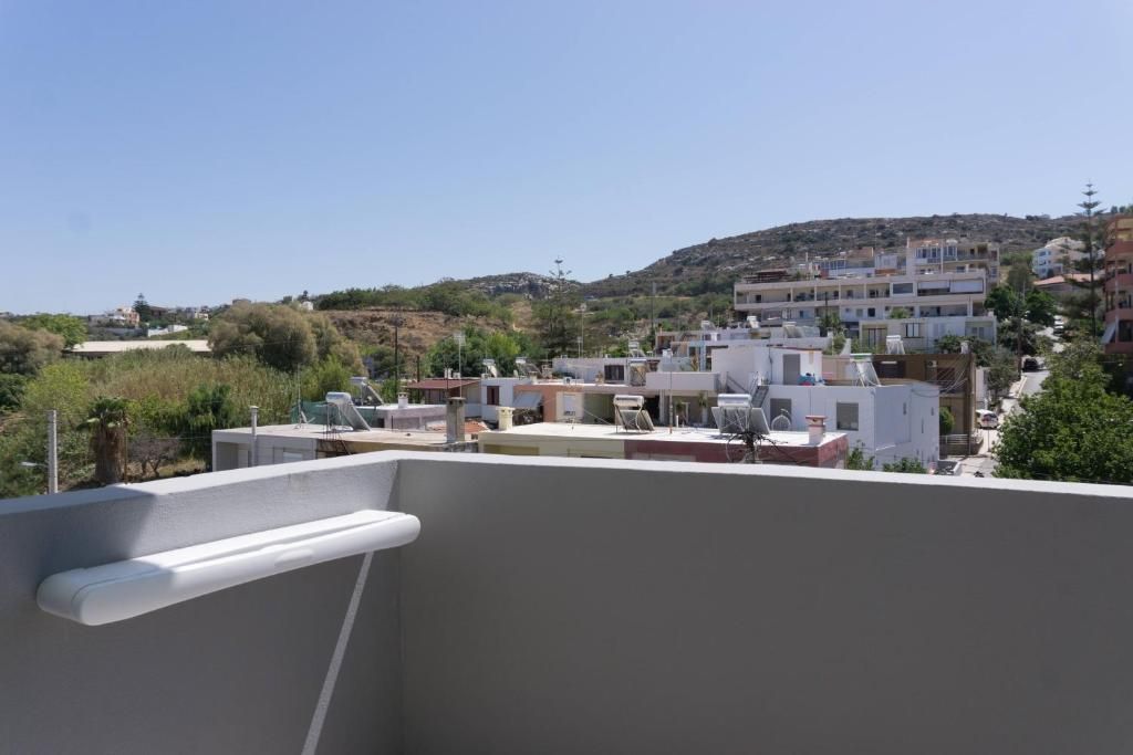 Uma área residencial com vários edifícios, alguns com telhados planos e outros inclinados, sob um céu claro.