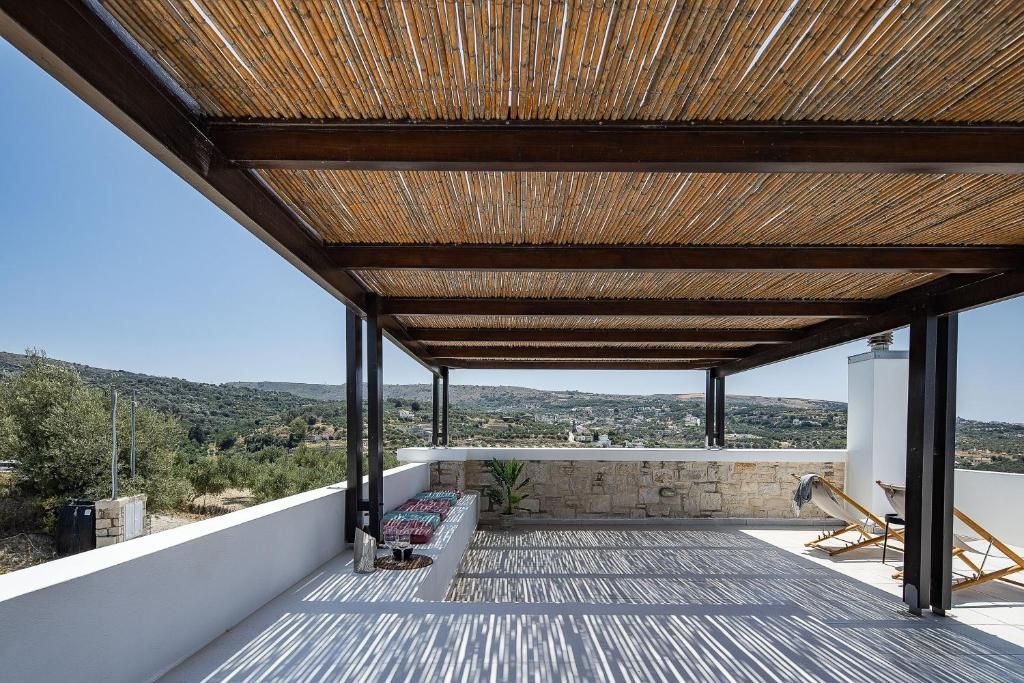 Um terraço coberto com vista para o campo.