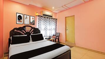 Quarto com cama, escrivaninha, cadeira e porta.