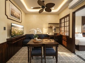 Quarto com mesa de jantar, cadeiras, sofá, ventilador de teto, televisão e cama.