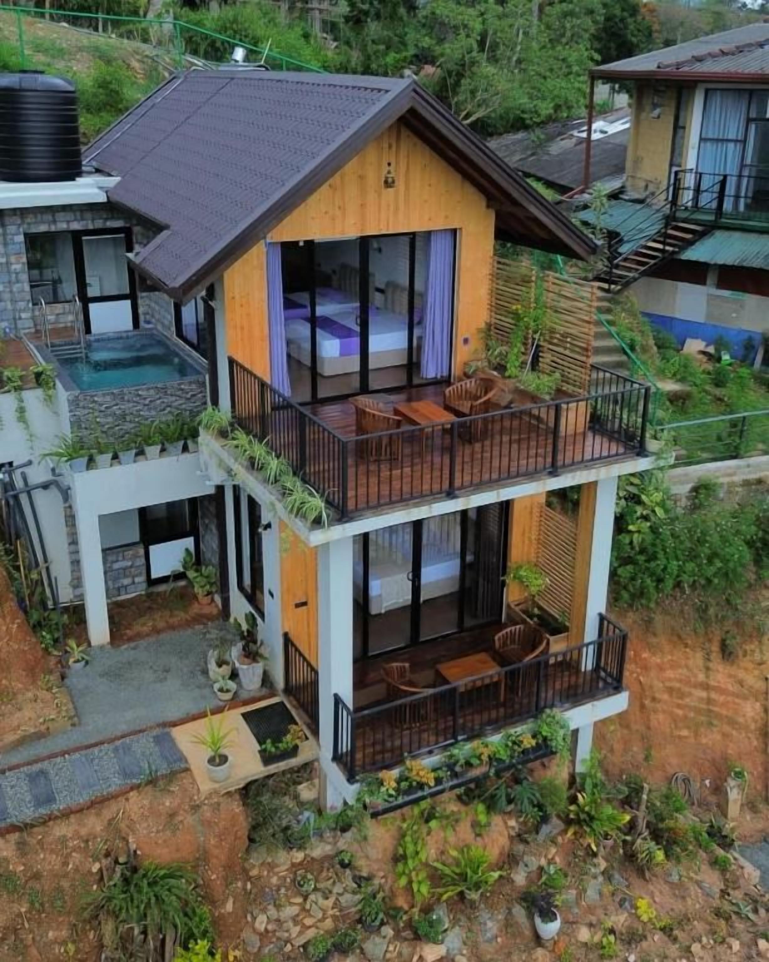 Uma casa de dois andares com varanda, piscina e jardim.