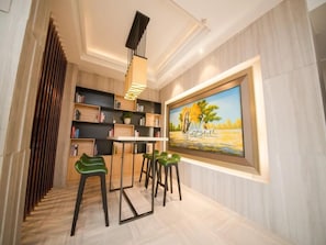 Um interior moderno com área de refeições, estantes de livros e uma pintura.