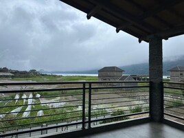 Varanda com vista para a paisagem costeira, incluindo um corpo d'água e edifícios ao longe.