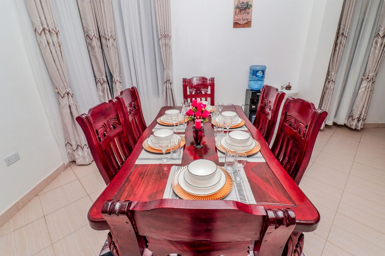 Mesa posta com pratos, copos e um arranjo central.