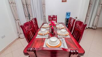 Mesa posta com pratos, copos e um arranjo central.