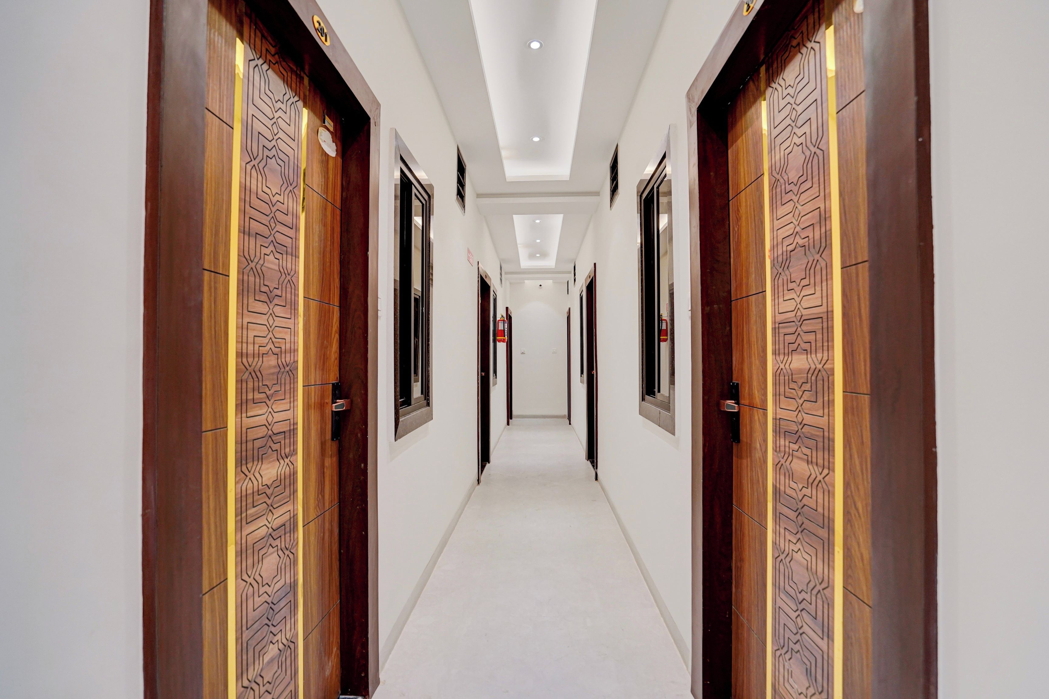 Um corredor com portas de madeira e carpete branco.
