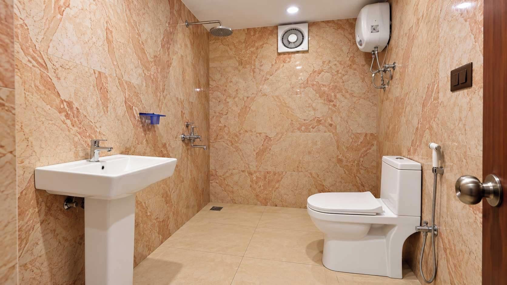Casa de banho com lavatório, sanita e chuveiro, e secador de mãos.