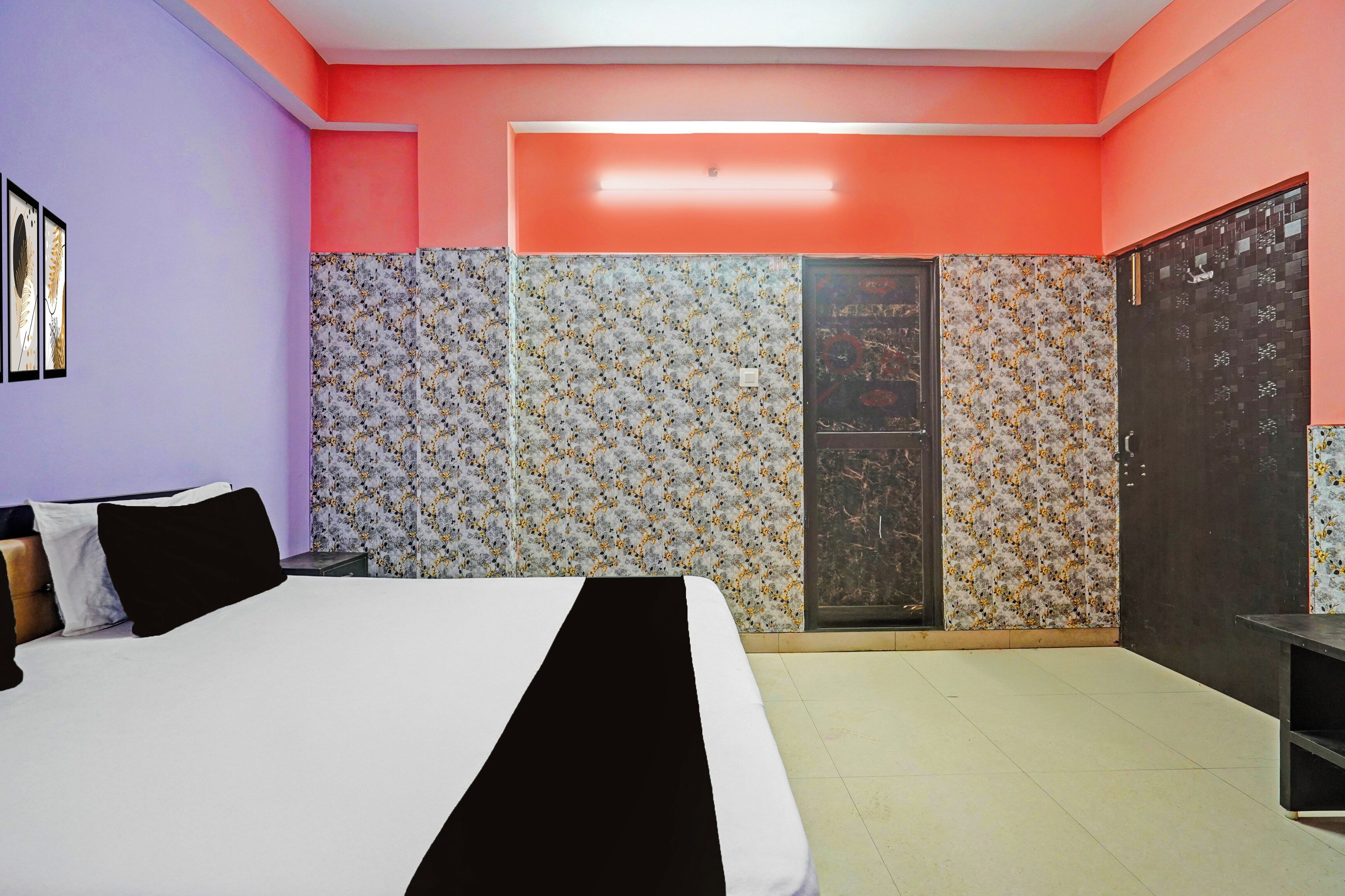 Quarto de hotel com cama, guarda-roupa e banheiro com espelho e pia.