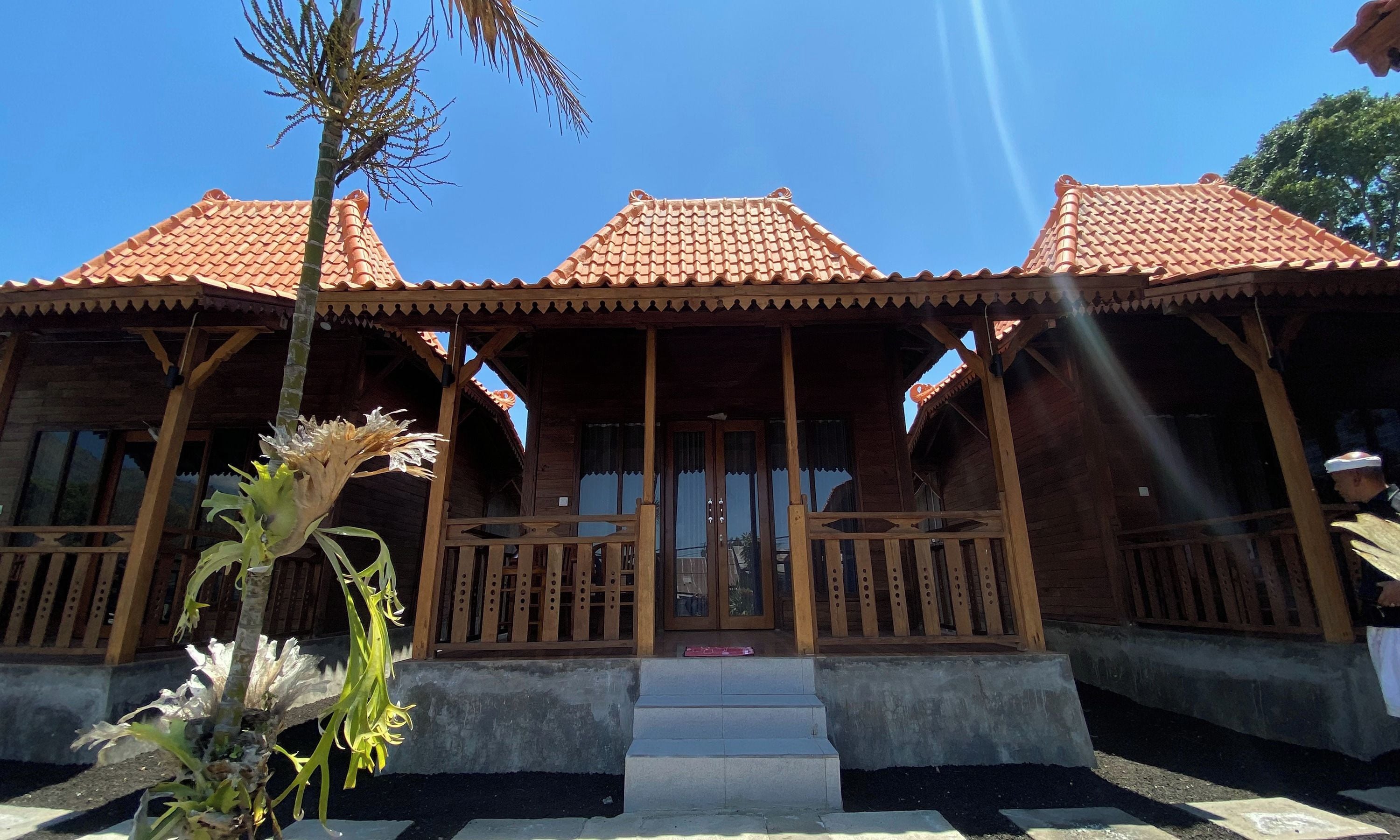Um edifício de madeira com telhado de cerâmica e varanda.