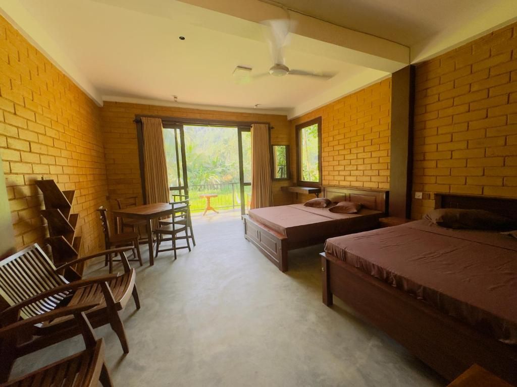 Quarto com cama, mesa, cadeiras, ventilador de teto e vista pela janela.