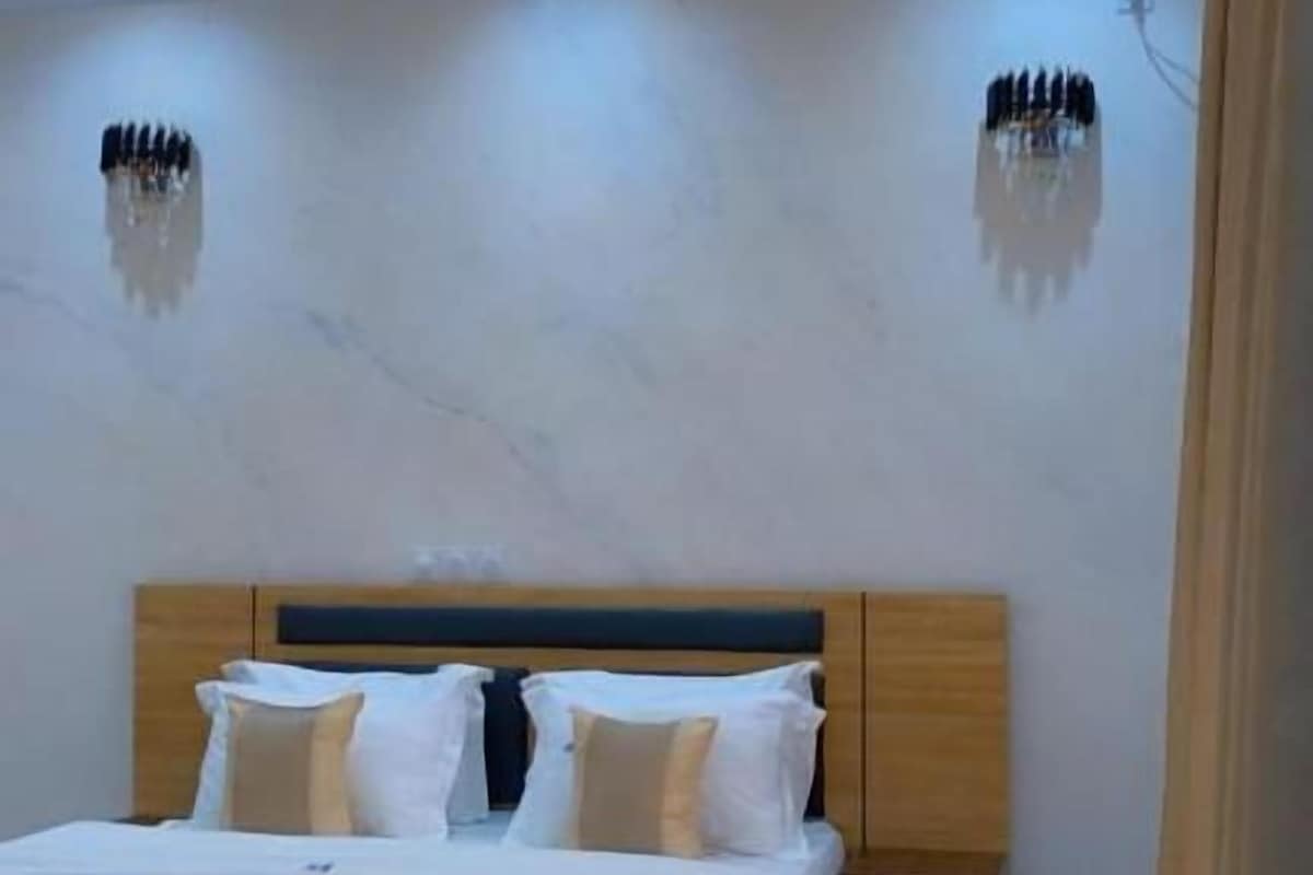 Quarto com cama, mesas de cabeceira e um design moderno no teto.