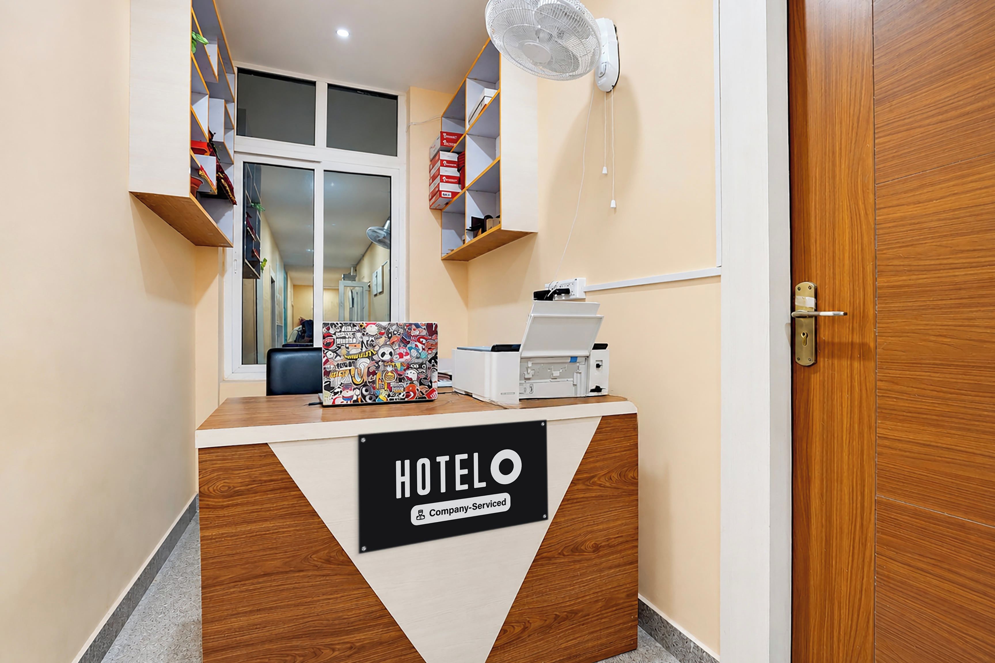 Uma mesa de recepção com uma placa que diz 'HOTEL' e 'Serviço da Empresa'.