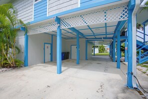 Área externa coberta com estrutura azul e teto de treliça branca.