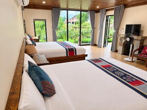 Quarto de hotel com duas camas, televisão e lareira.