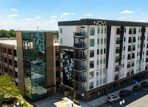 Um hotel com vários andares, design moderno, com varandas e grandes janelas.