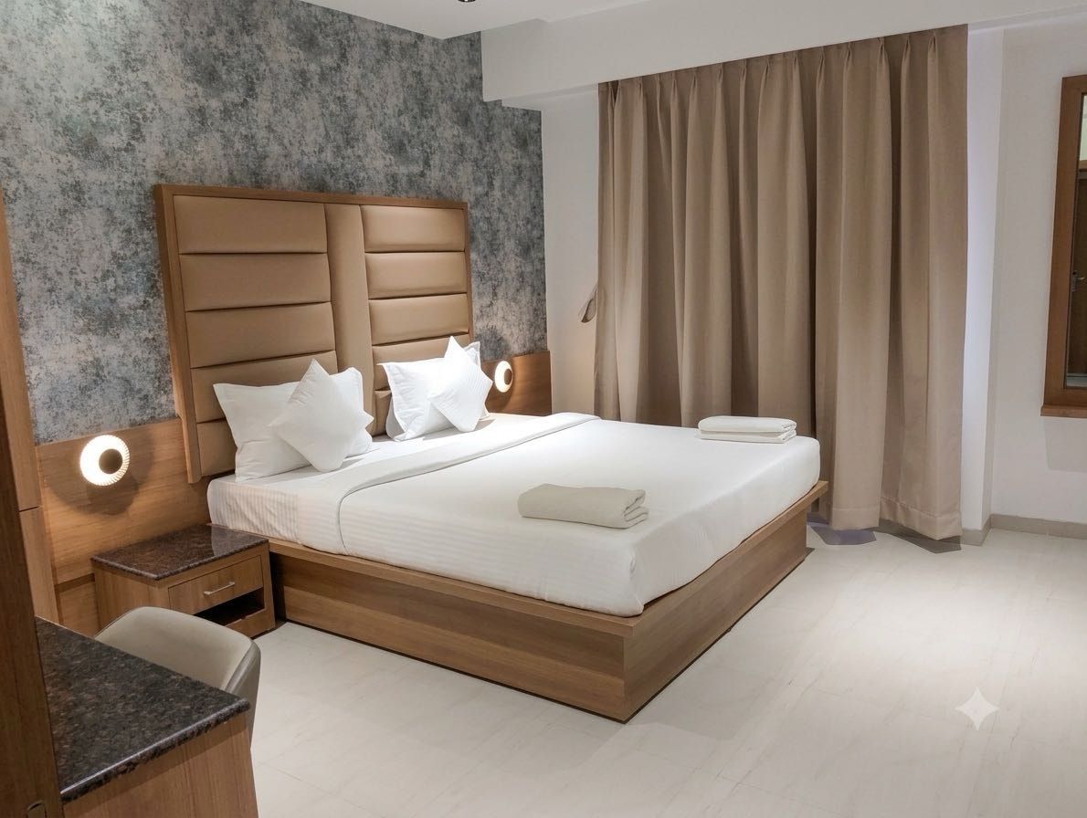 Quarto de hotel moderno com cama grande, cabeceira de madeira, mesas de cabeceira e vista exterior.