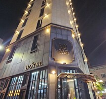 Um hotel com fachada moderna, letreiros iluminados e entrada convidativa.