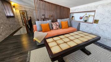 Uma sala de estar moderna com um sofá, uma mesa de centro e um painel decorativo na parede.