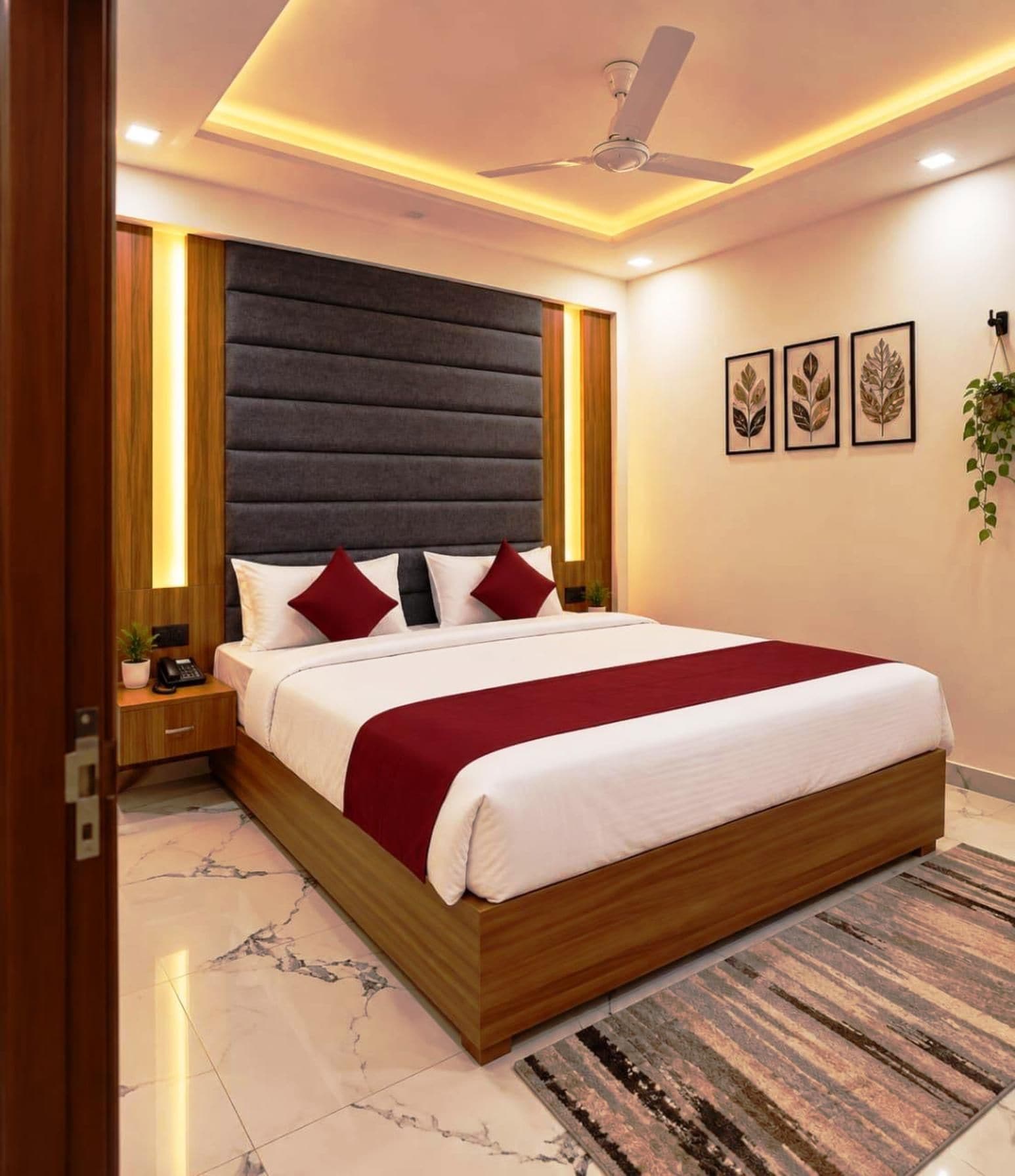 Quarto moderno com uma cama grande, um ventilador de teto e uma mesa de cabeceira com abajur.