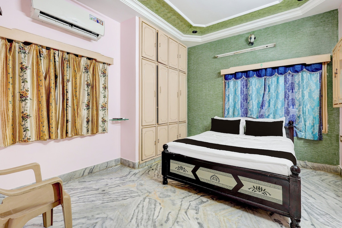 Quarto com cama, guarda-roupa, cadeira e ar-condicionado.