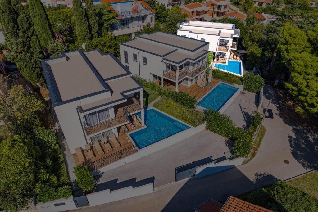Um empreendimento residencial moderno com uma grande piscina, várias varandas e um jardim bem cuidado.