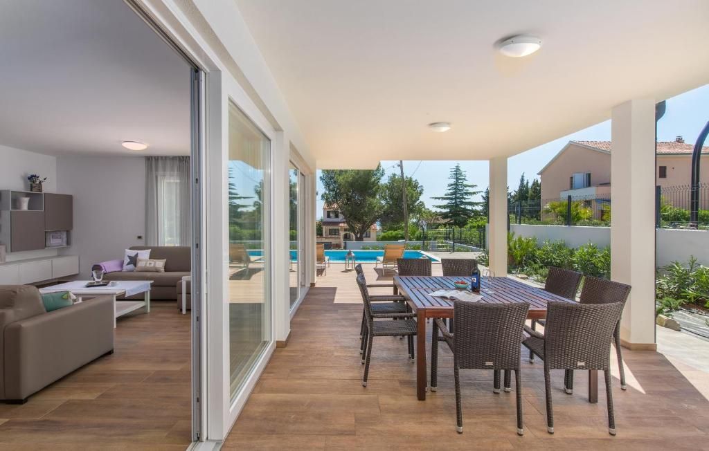 Uma sala de estar moderna com sofá, mesa de centro e área de jantar com cadeiras e mesa.