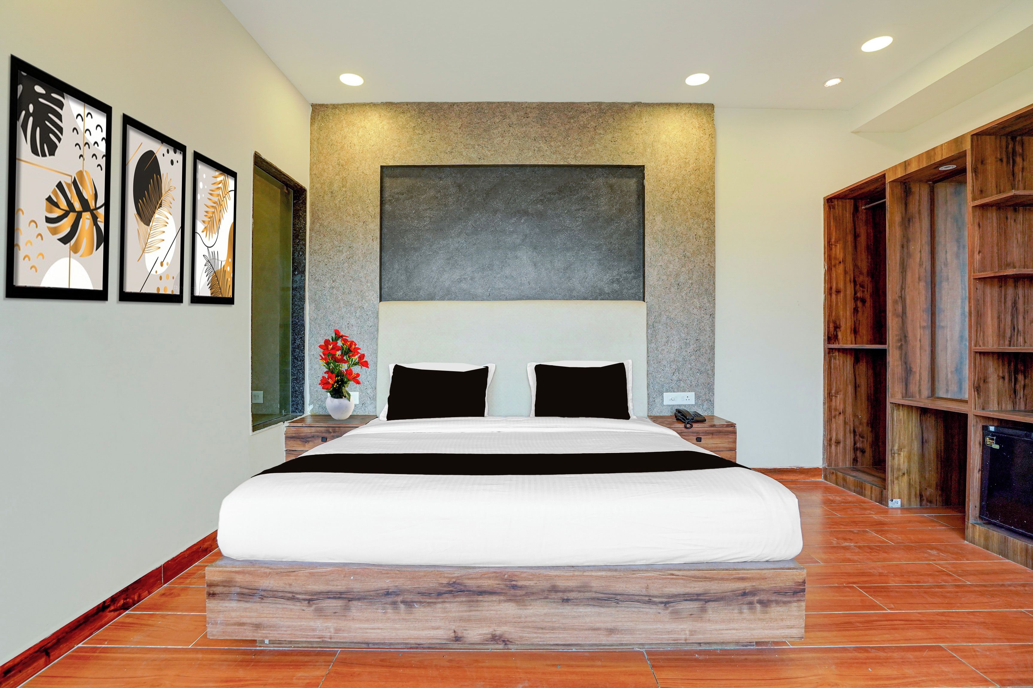 Quarto moderno com cama grande, parede de pedra decorativa e estante de madeira.