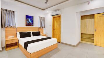 Quarto com cama de madeira, mesa de cabeceira, guarda-roupa e ventoinha no teto.