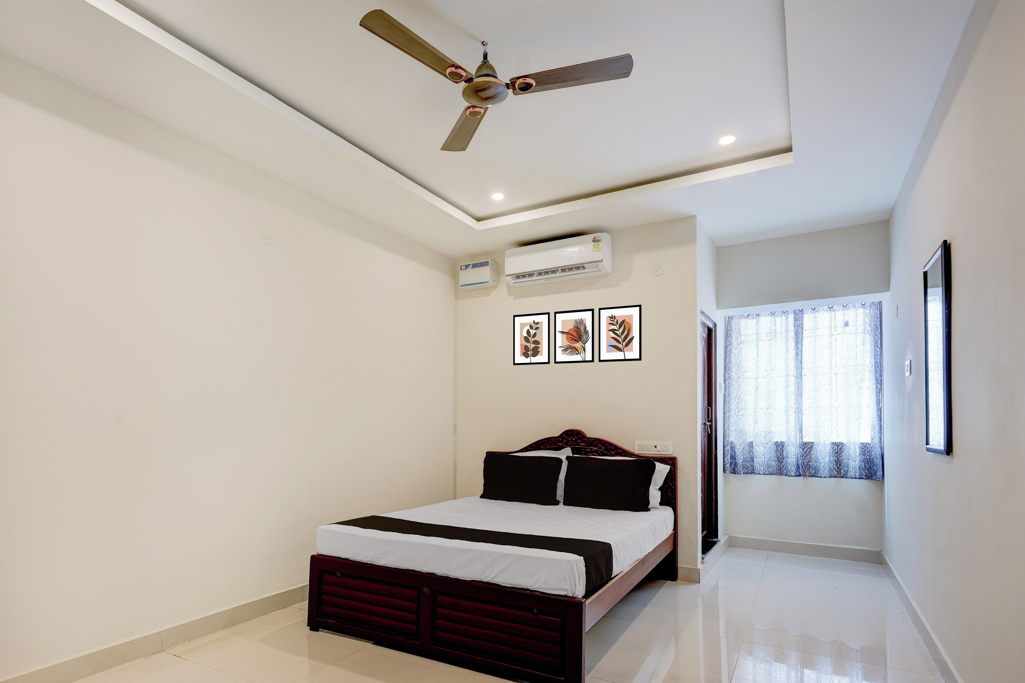Quarto com cama, ventilador de teto, ar-condicionado e quadro na parede.