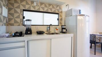 Cozinha moderna com máquina de lavar louça embutida, cafeteira e liquidificador na bancada.