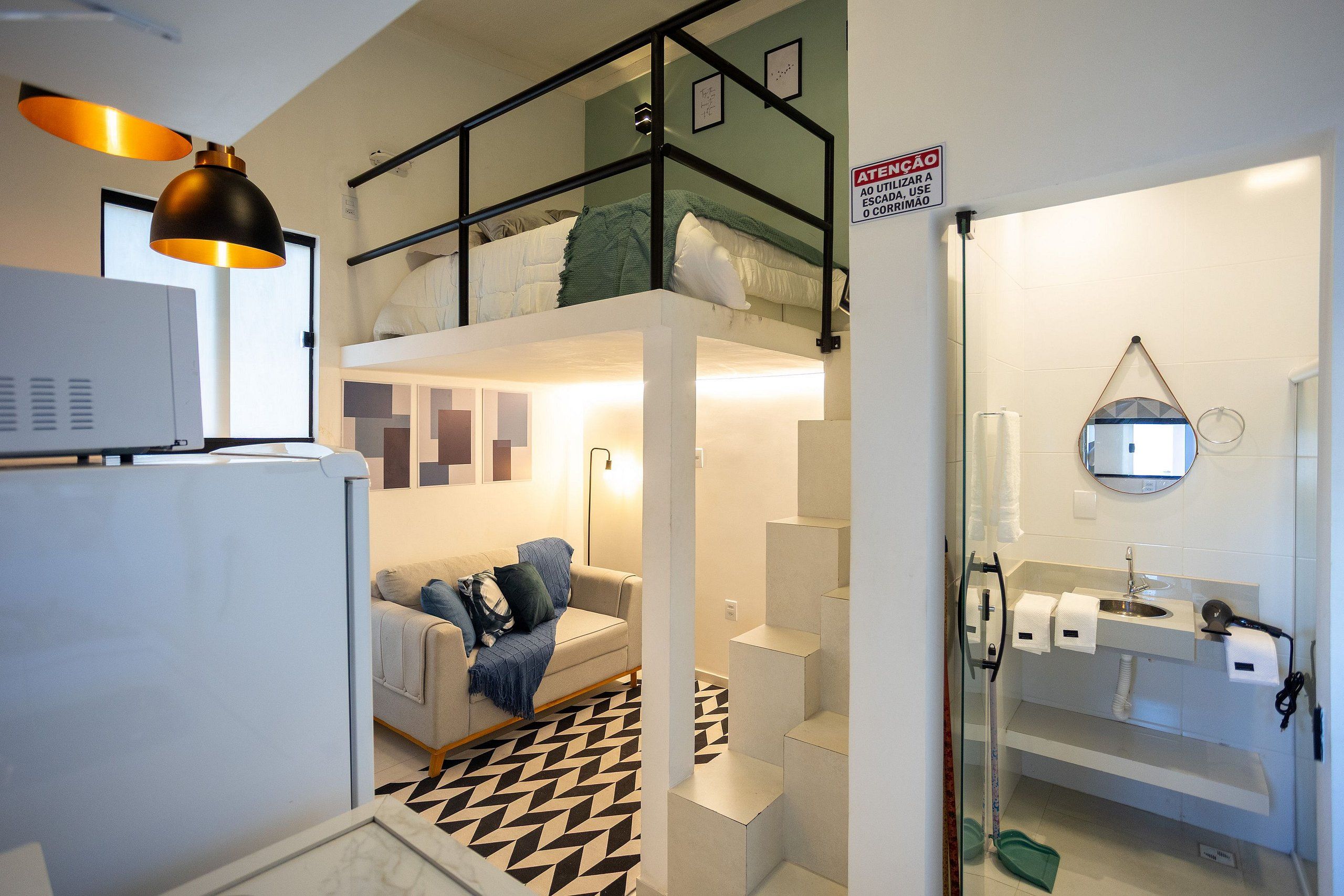 Apartamento compacto e moderno, com quarto no mezanino, cozinha americana e banheiro.
