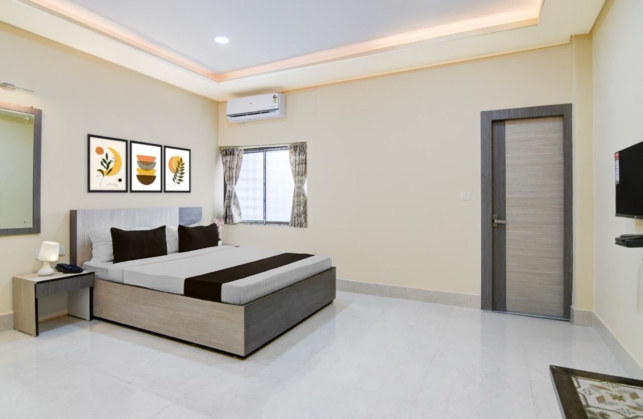 Quarto moderno com cama, mesa de cabeceira, aparelho de ar condicionado e obra de arte na parede.