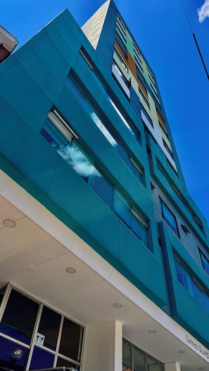 Um edifício moderno com fachada triangular de vidro e telhado plano.