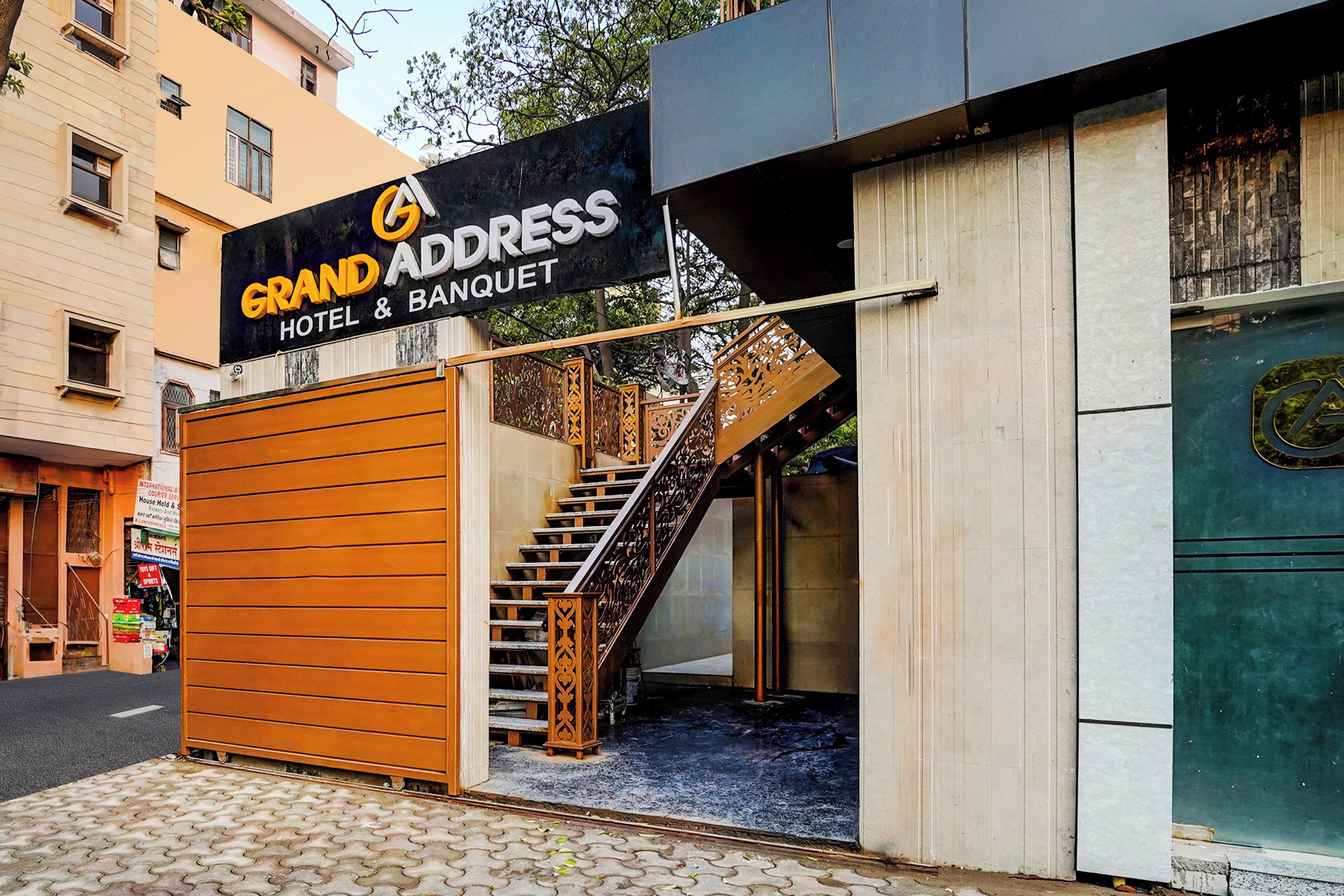 Entrada de hotel com placa indicando 'Grand Address Hotel & Banquet'.