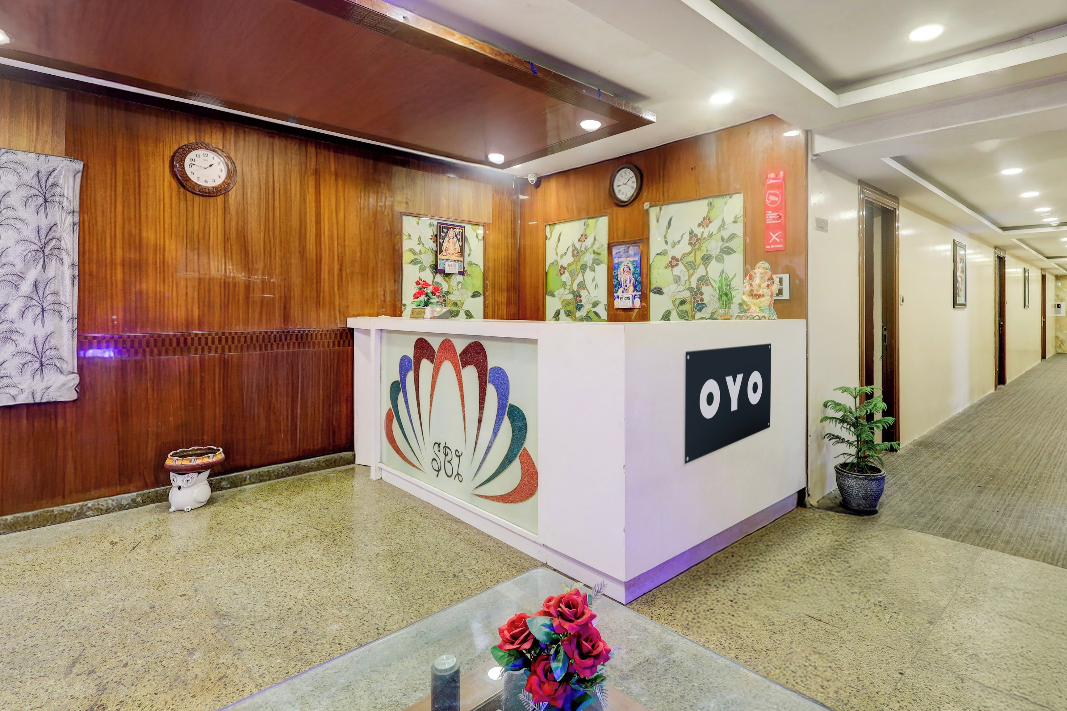 Bancada de recepção com logotipo, relógio e placa indicando área proibida para fumantes.