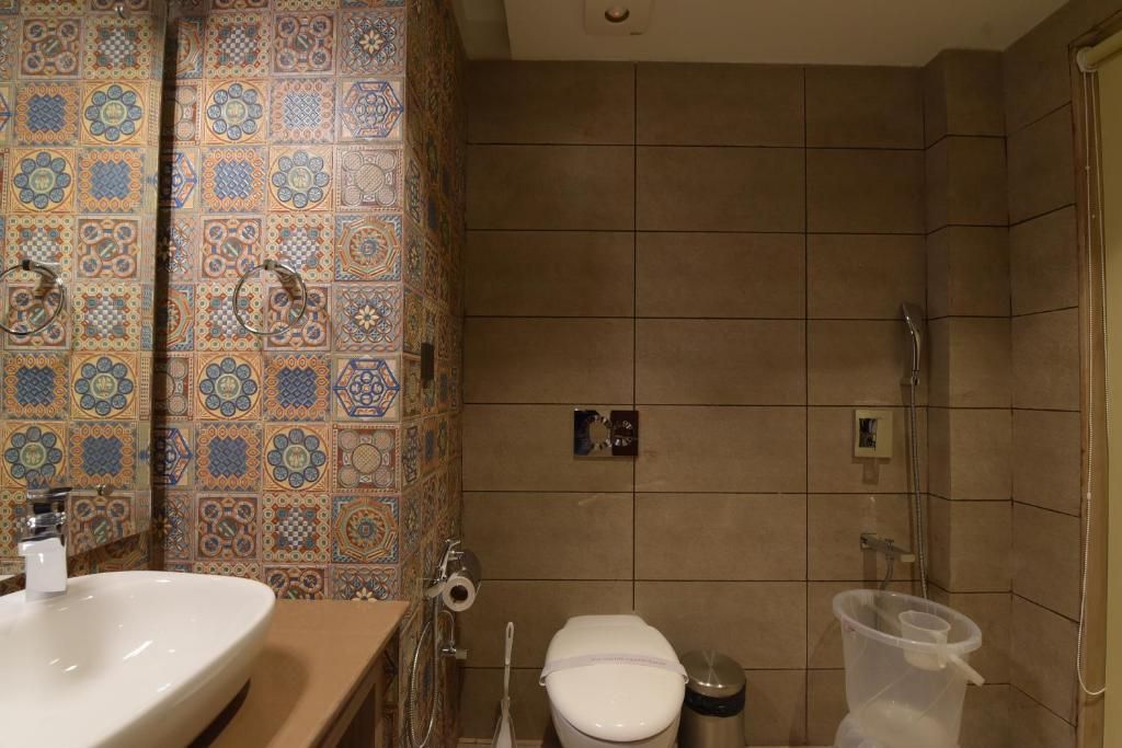 Uma casa de banho com lavatório, sanita e chuveiro.
